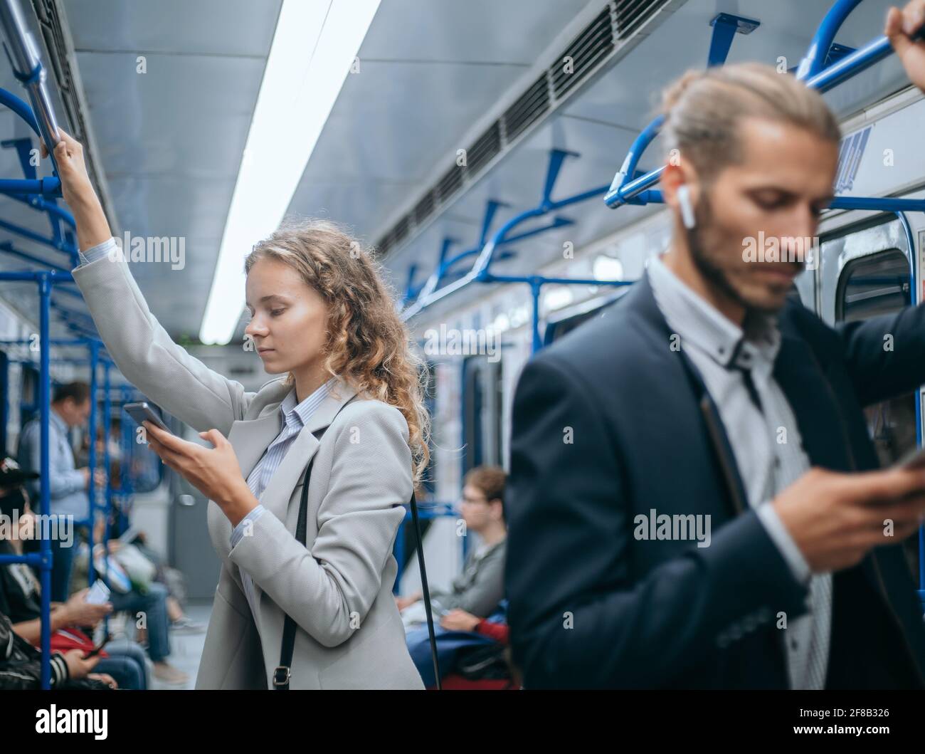 passengers using their smartphones in the subway car Stock Photo - Alamy