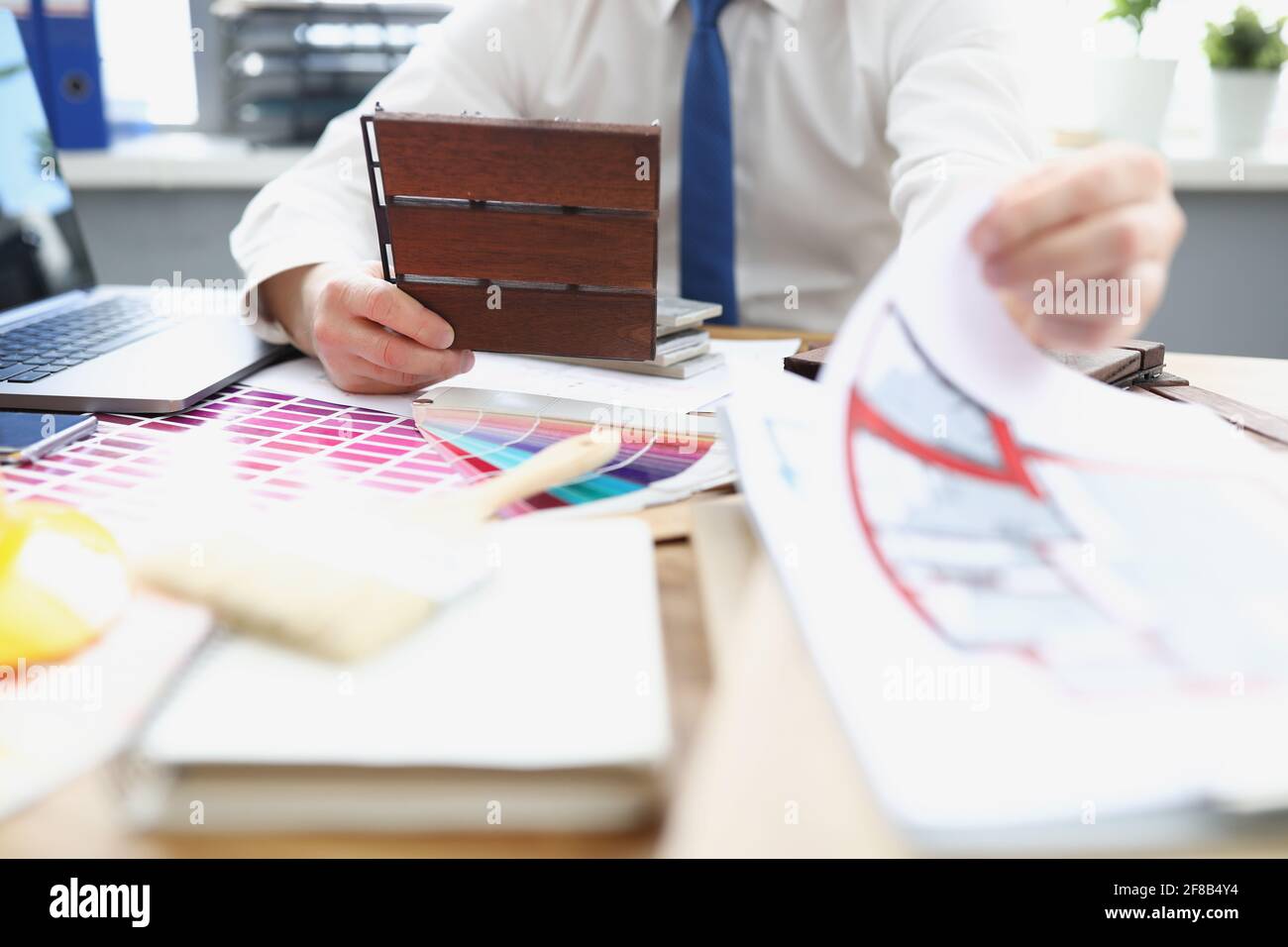 Designer demonstrates samples of building materials at work table Stock ...