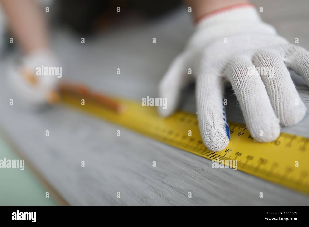 Hands of master making measurements with ruler on laminate Stock Photo ...