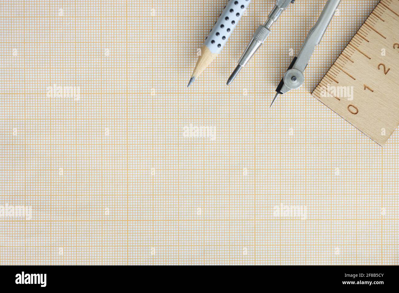 Wooden ruler, compasses and pencil lie on graph paper Stock Photo - Alamy