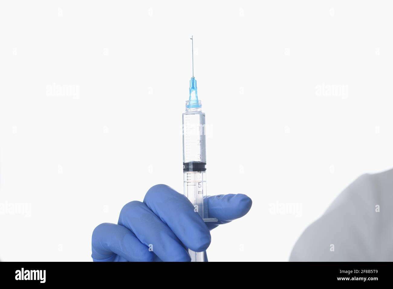 Syringe with needle in the hand of gloved doctor Stock Photo - Alamy