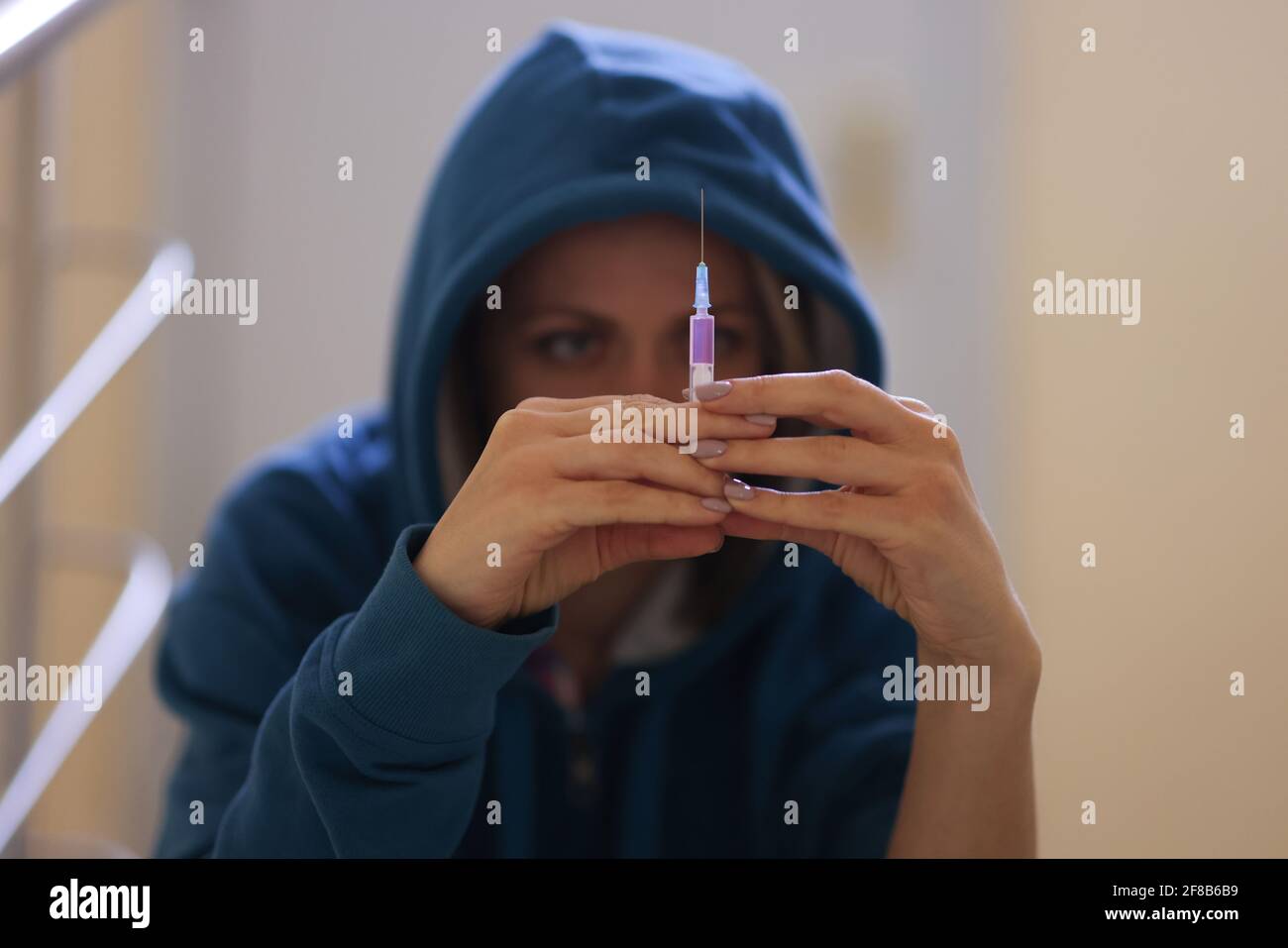 Woman drug addict sits on stairs with syringe Stock Photo - Alamy