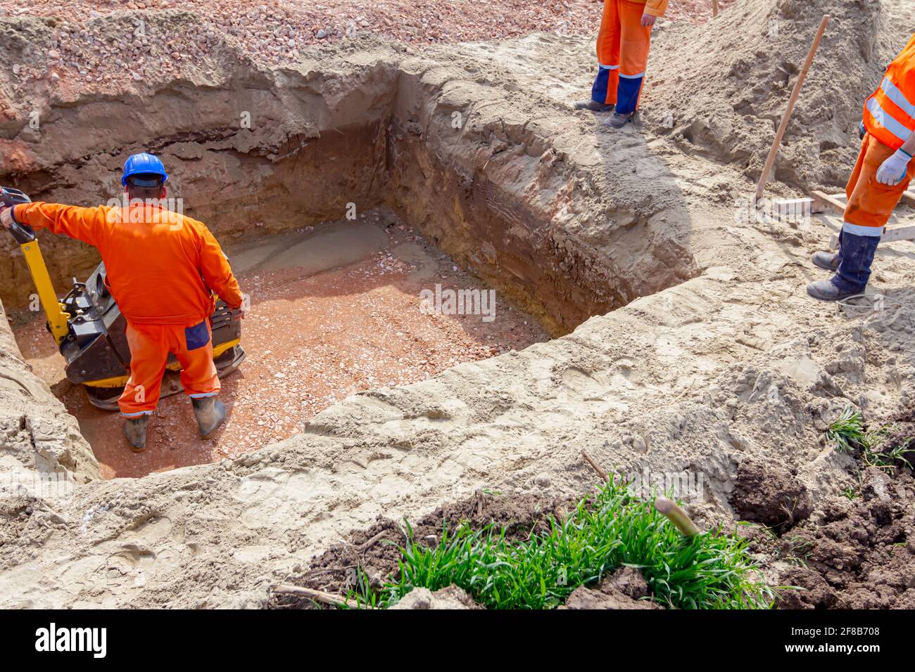 Worker is compacting gravel with vibration plate compactor machine in ...