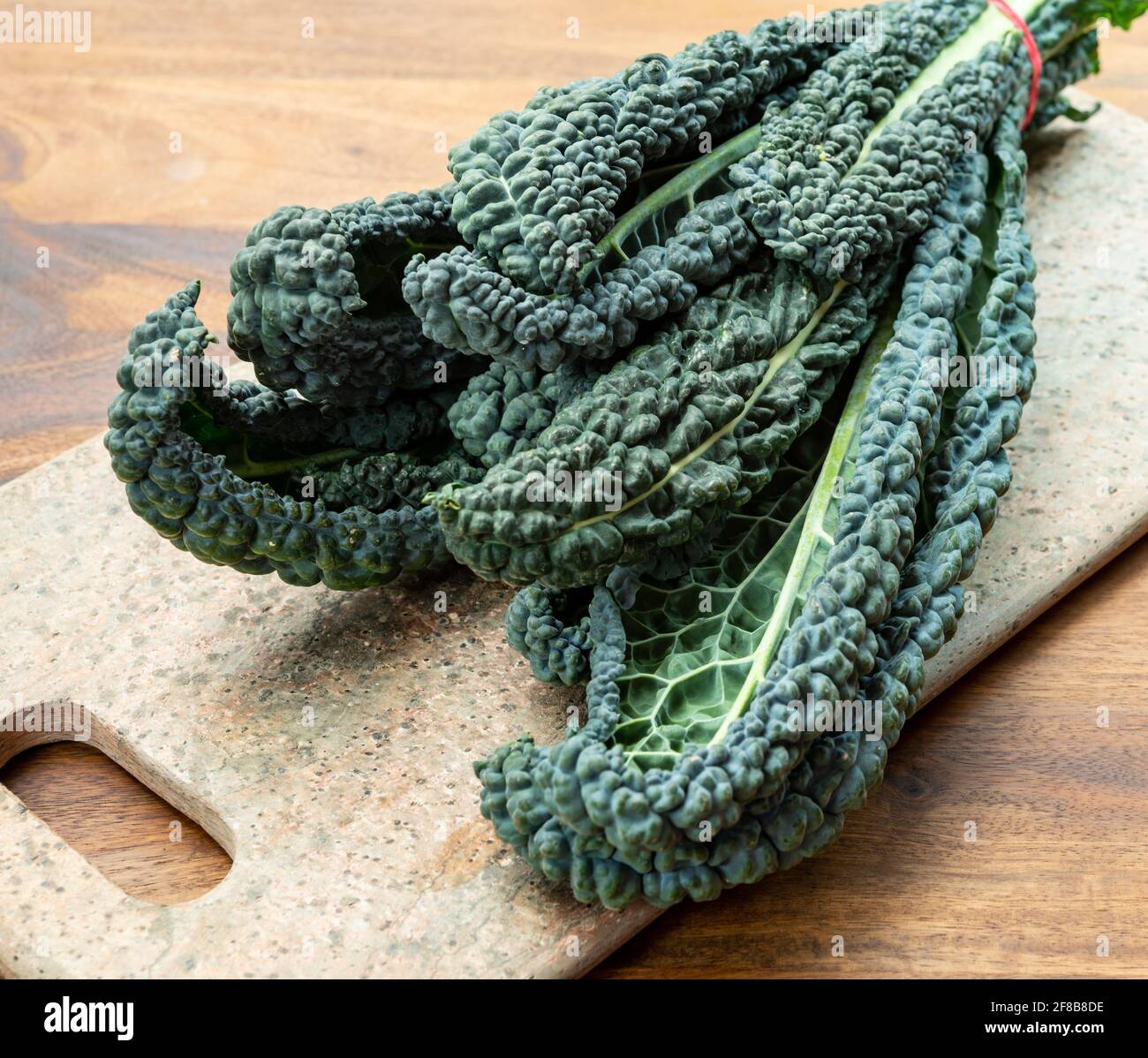 Vegetarian cooking with black flat leaves of cavolo nero tuscan cabbage ...