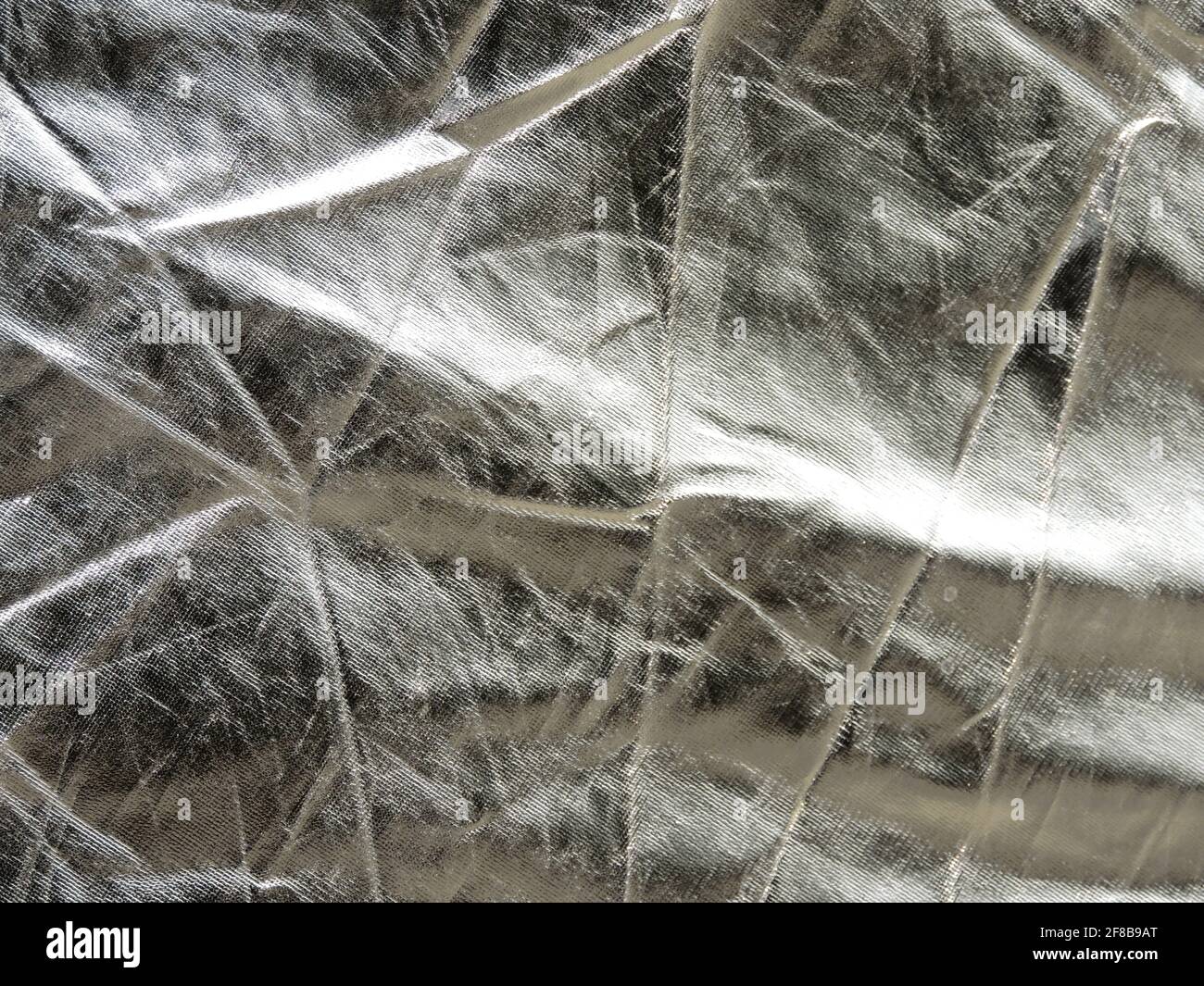 Closeup of shiny silver fabric with folding marks - perfect for ...