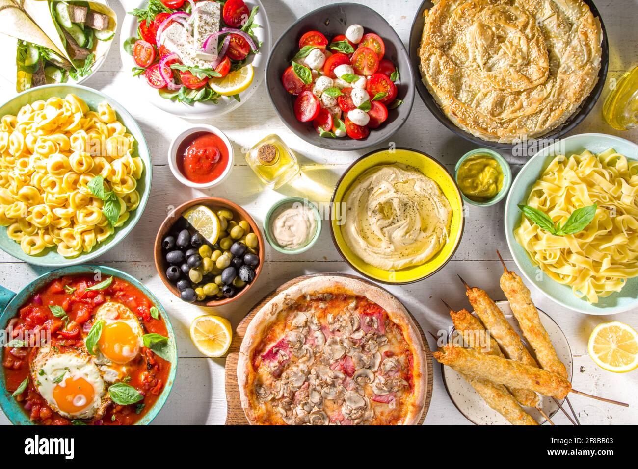 Set of different Mediterranean foods: olives, mozzarella tomato salad ...