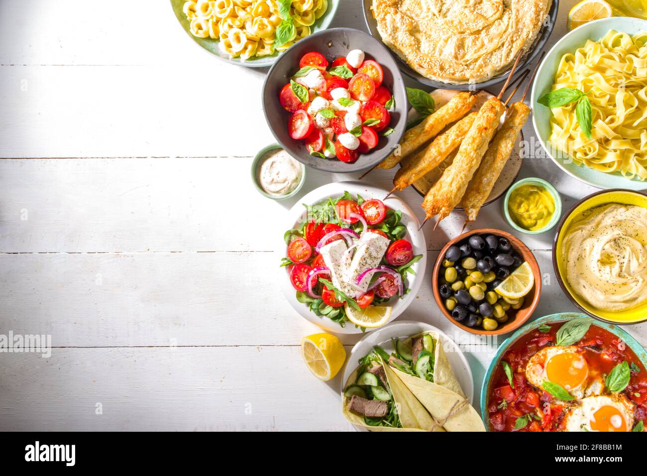Set of different Mediterranean foods: olives, mozzarella tomato salad ...