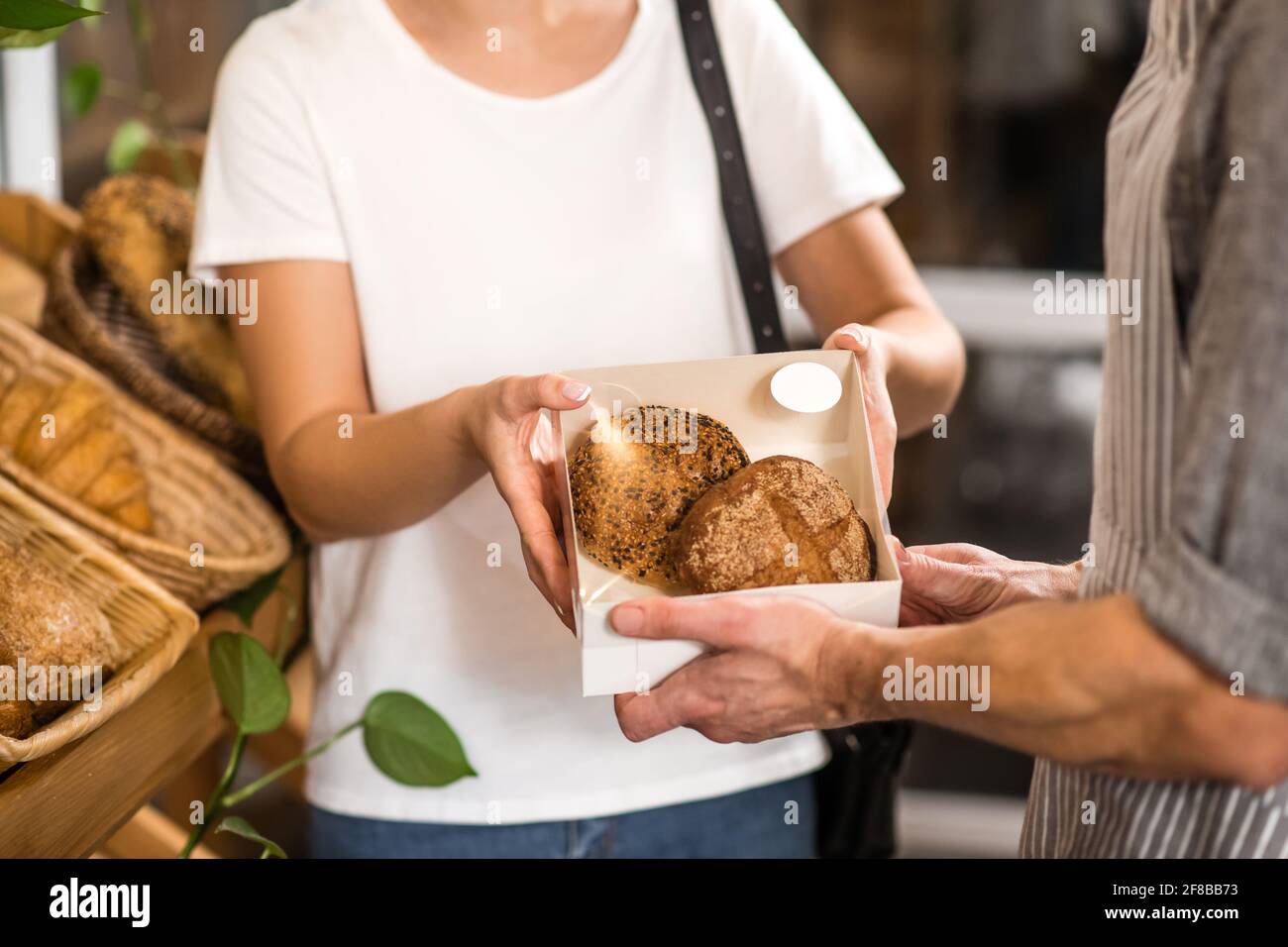 Female and male hands holding box of buns Stock Photo - Alamy