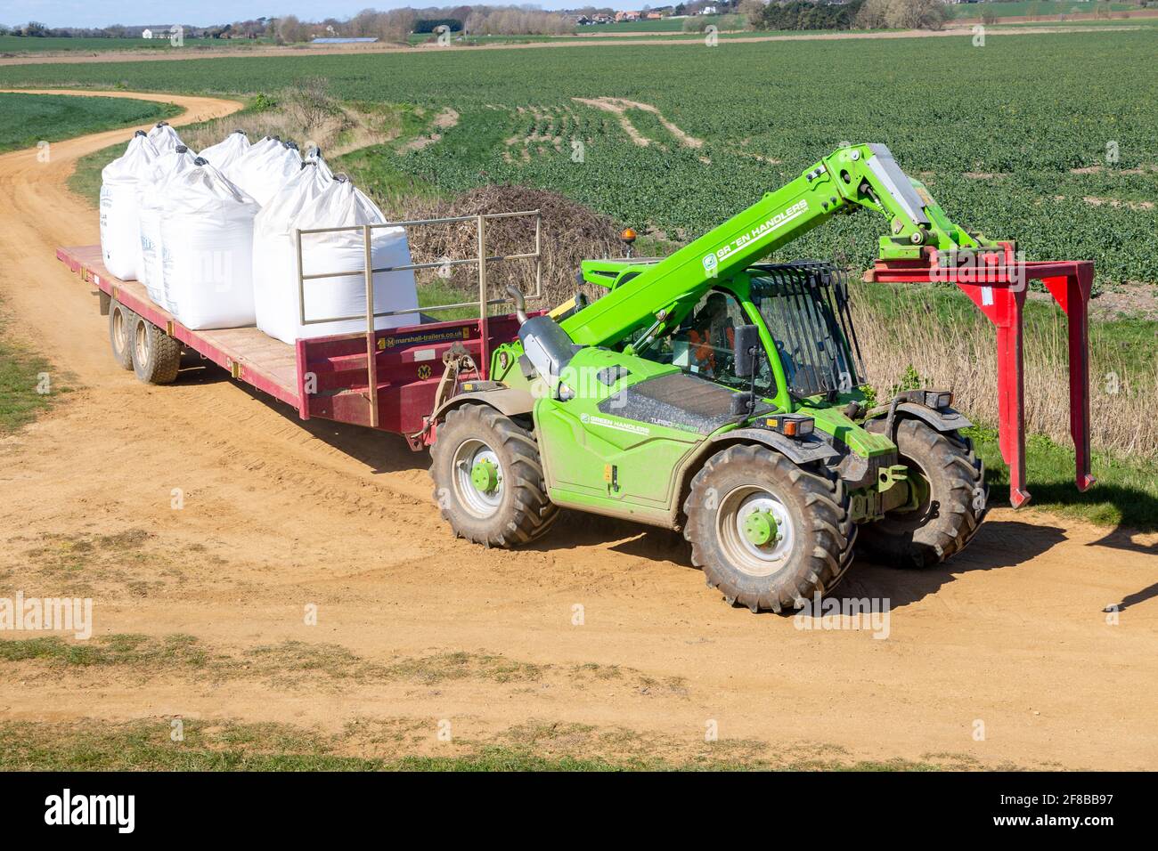 Telehandler vehicle with trailer carrying bags of nitrate fertiliser ...
