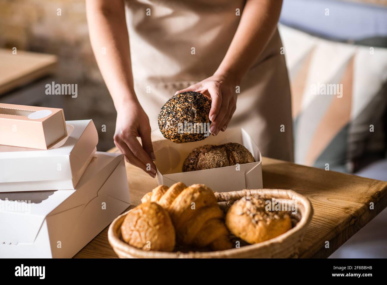 Female hands packing bread bun into box Stock Photo - Alamy
