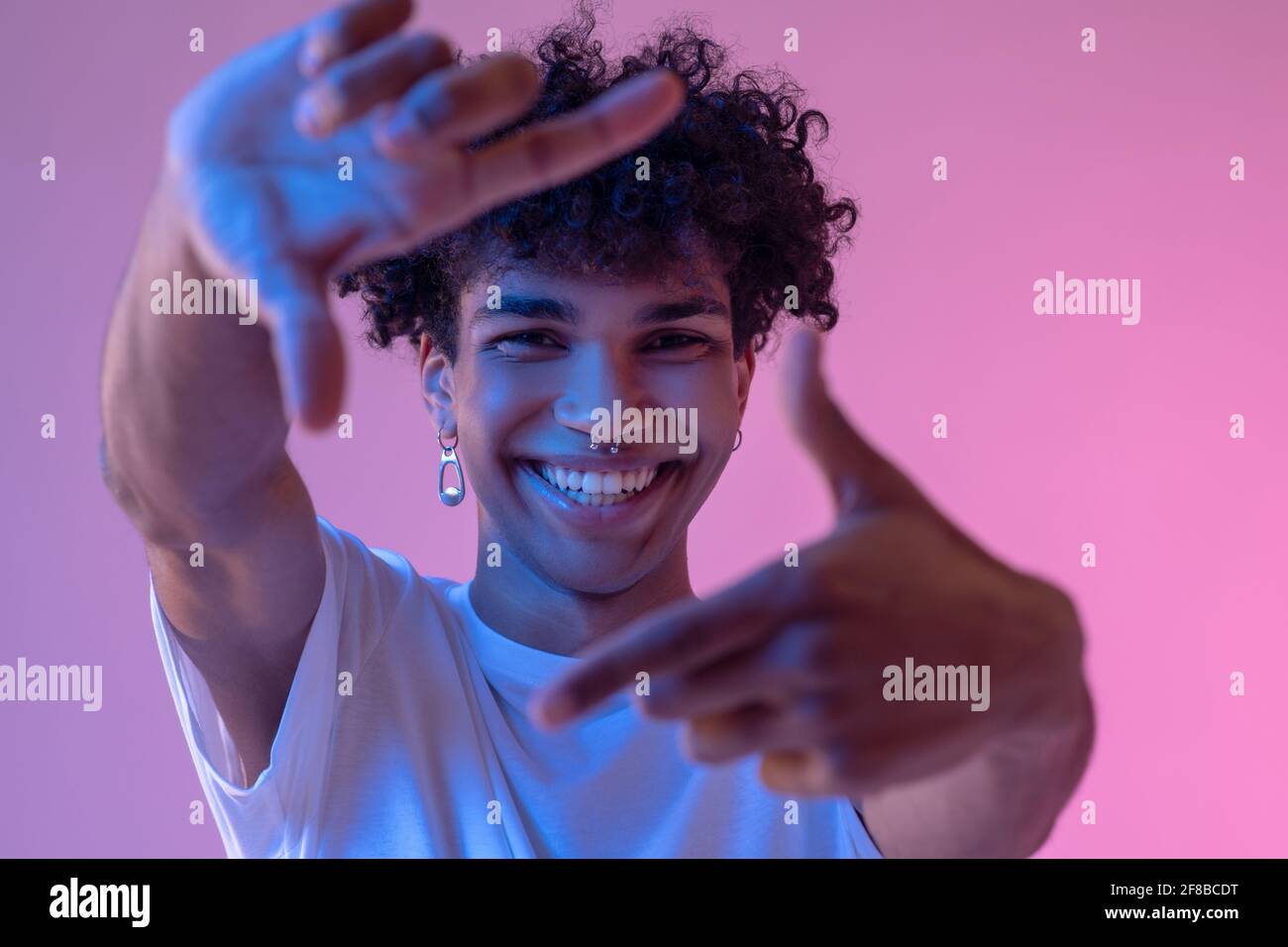 Dark-skinned guy making pictures with imaginary camera Stock Photo - Alamy