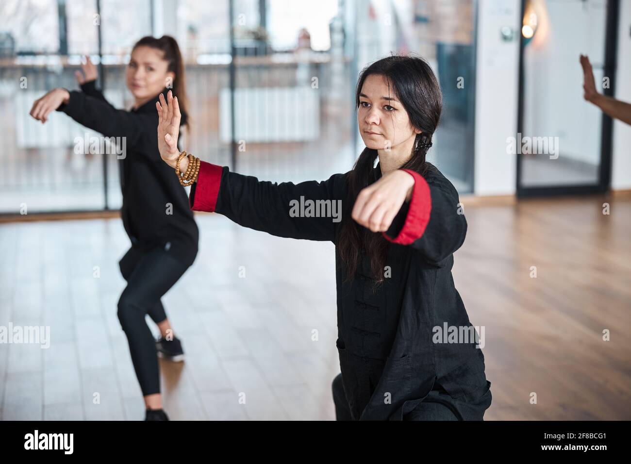 Bored martial arts trainer showing tai chi position Stock Photo - Alamy