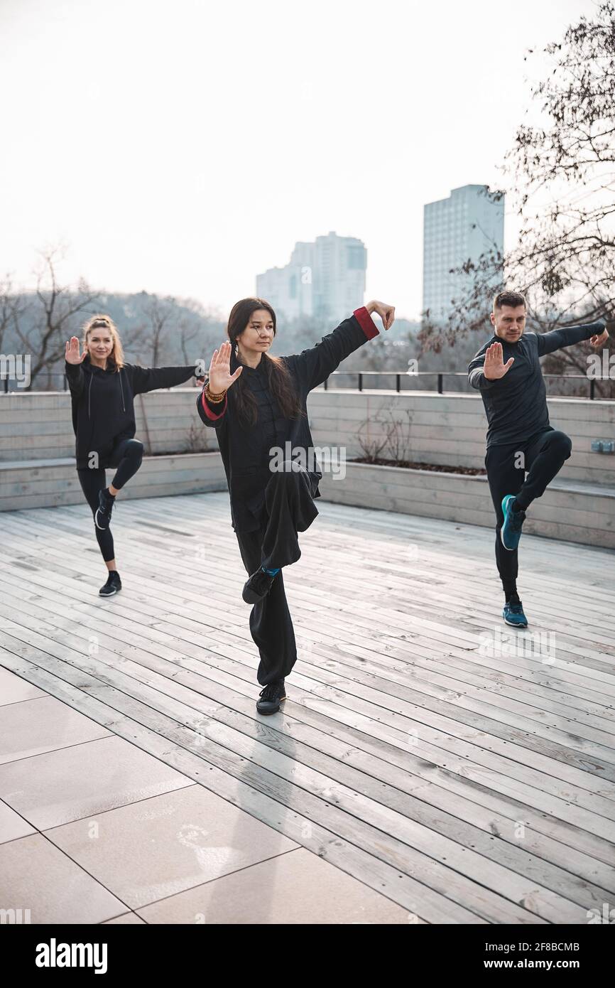 Tai chi outside on roof during exercise on one leg Stock Photo - Alamy