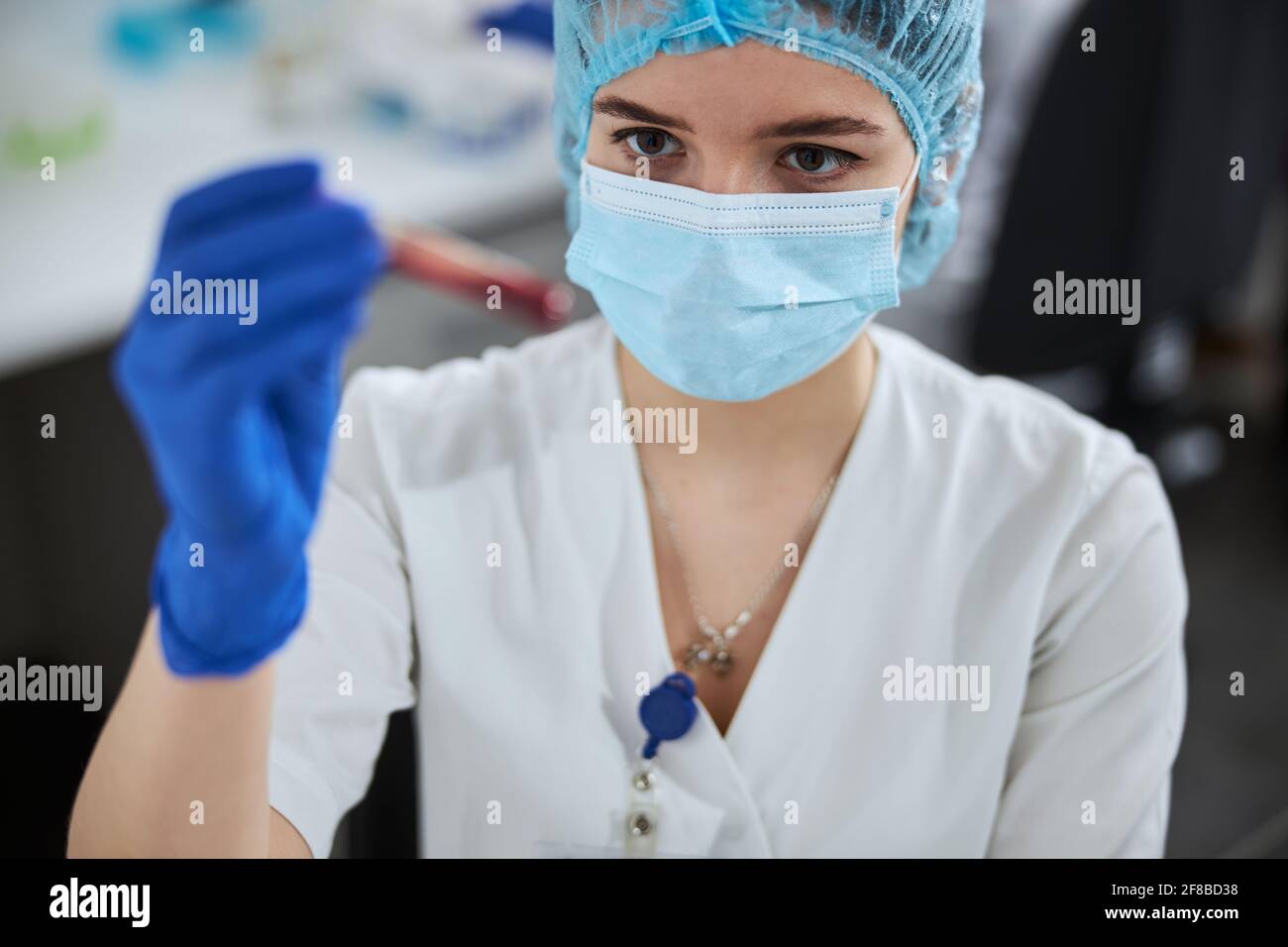 Medical laboratory scientist holding a test tube before the eyes Stock ...
