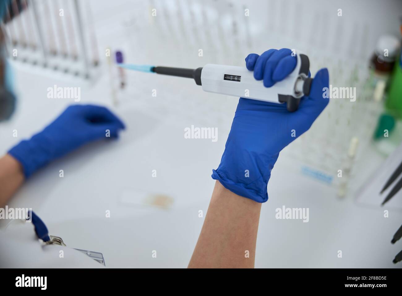 Qualified biochemist using a laboratory tool for a blood test Stock ...