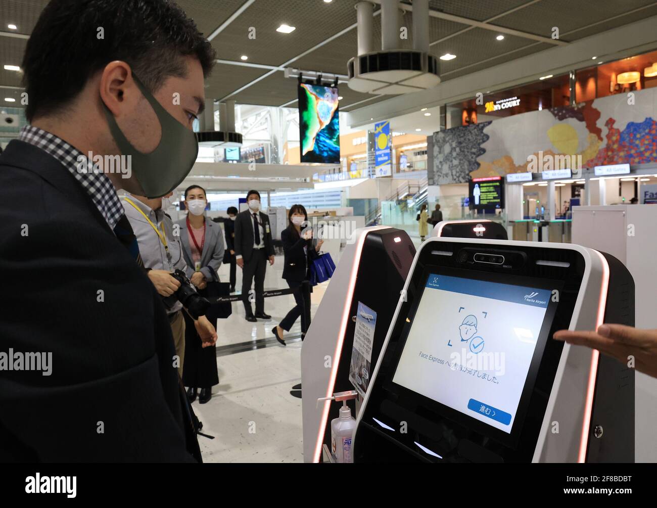 Narita, Japan. 13th Apr, 2021. A model demonstrates to check in a kiosk ...