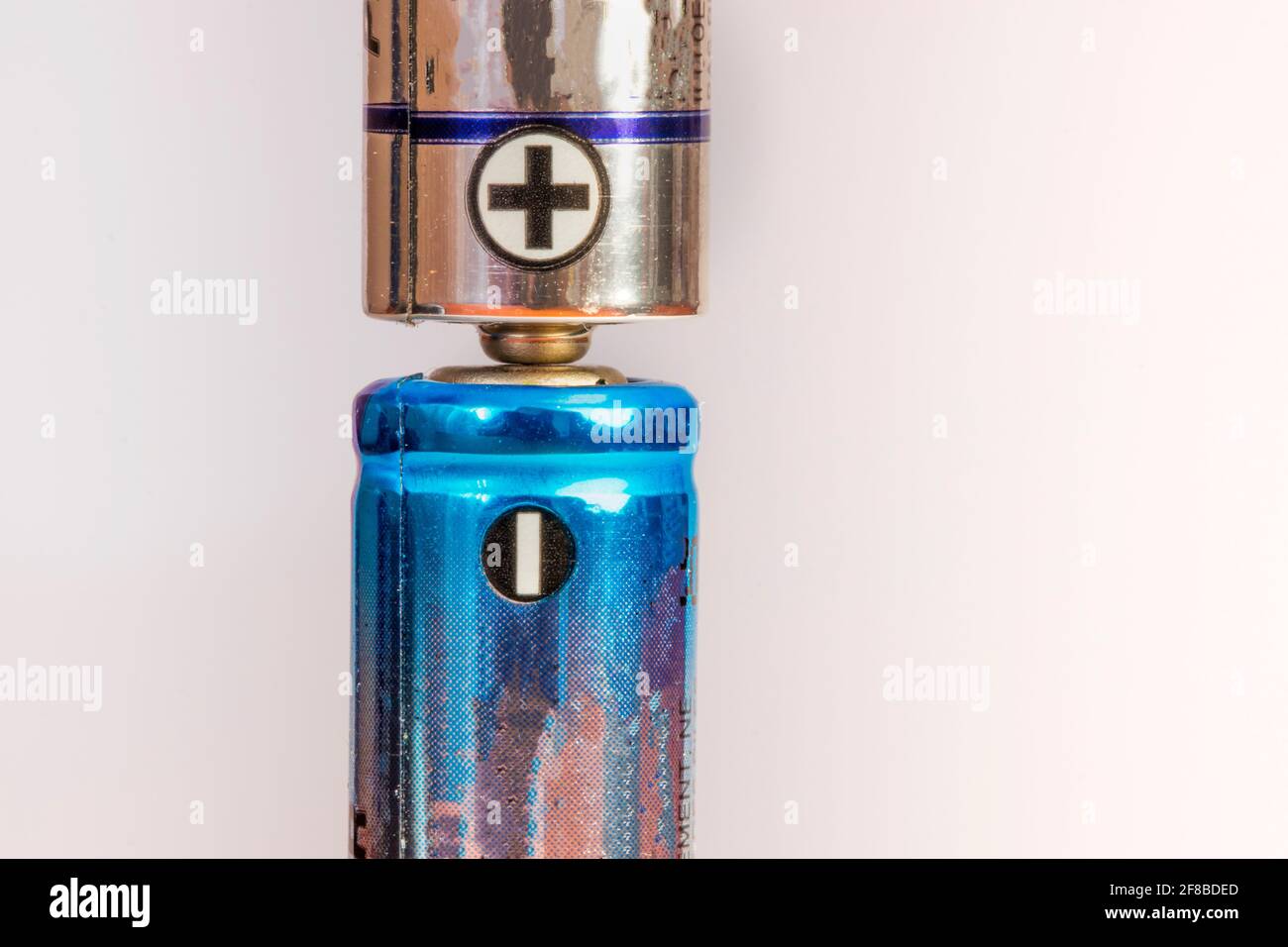 Closeup of one positive and one negative battery stuck to each other ...
