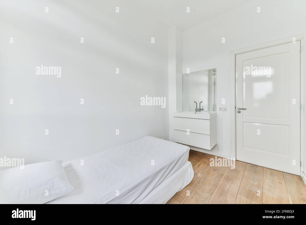Bed and bedside table near window Stock Photo - Alamy