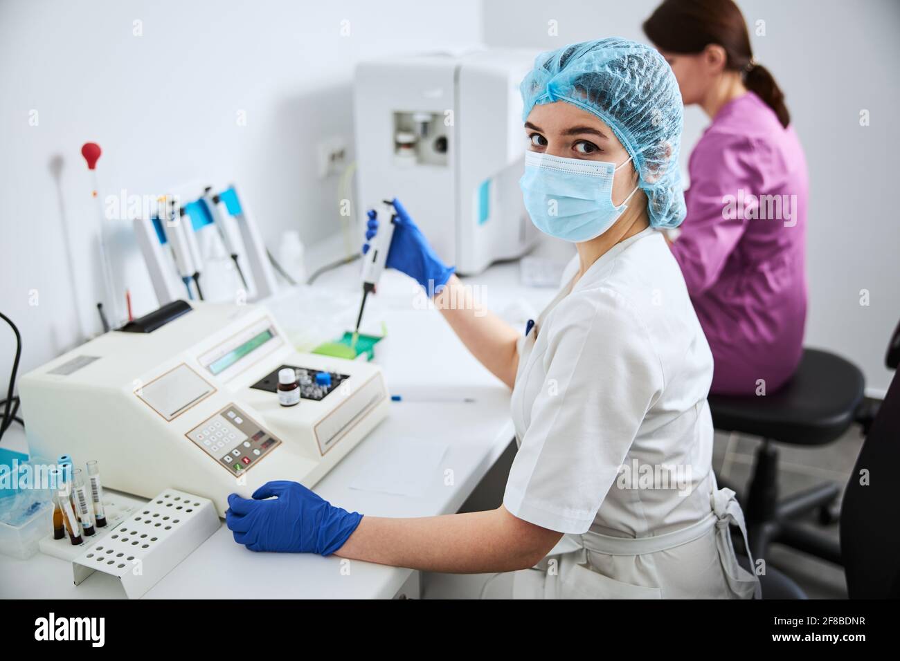 Biochemist in a face mask posing for the camera at work Stock Photo - Alamy