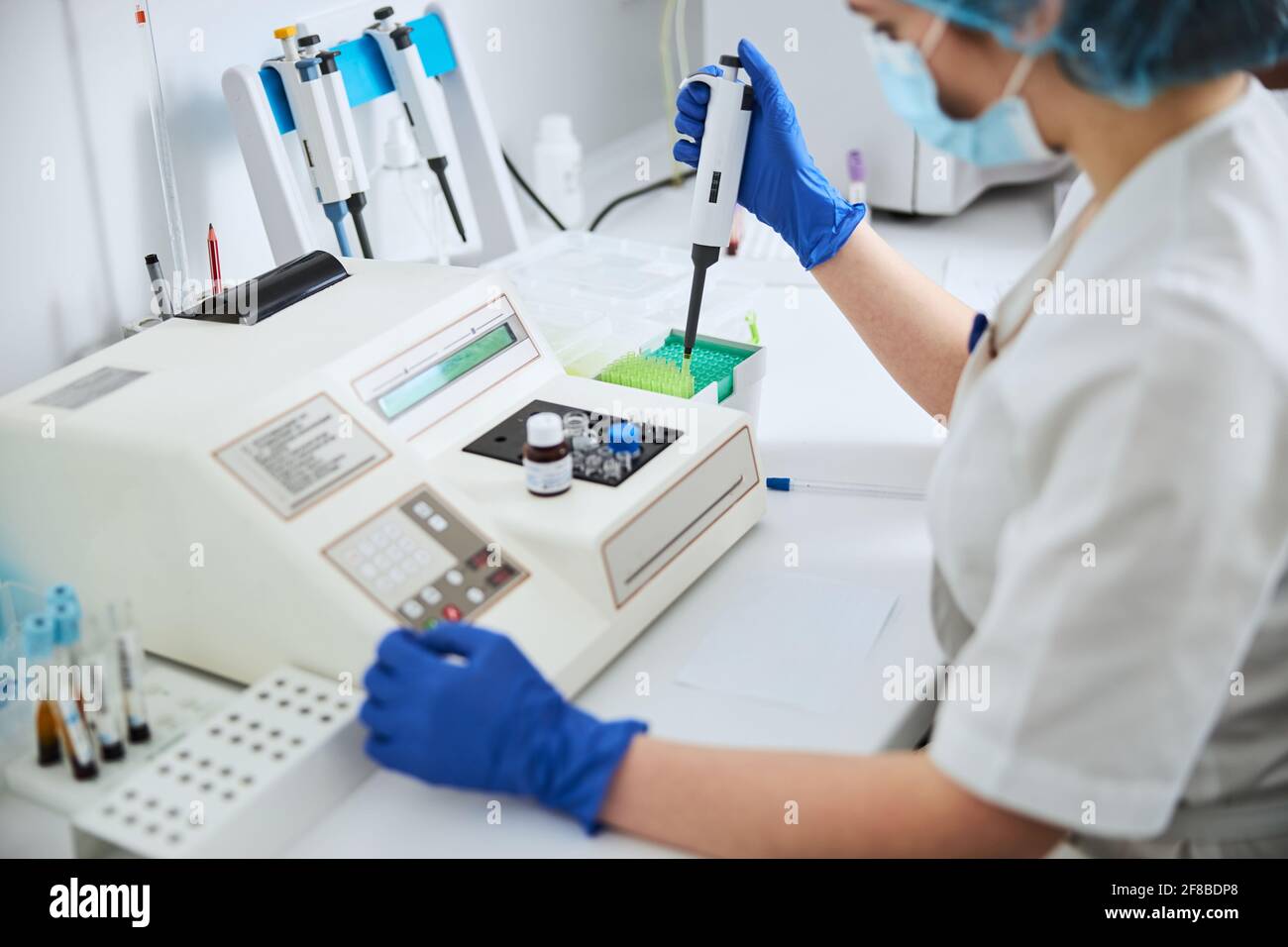Scientist in a mask preparing a laboratory tool for pipetting Stock ...