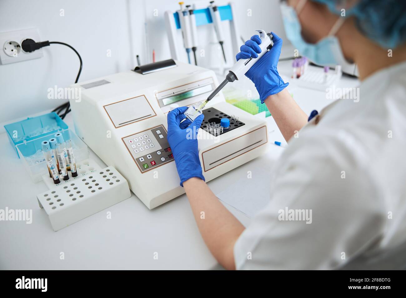 Medical lab technician drawing off liquid from a reagent bottle Stock ...