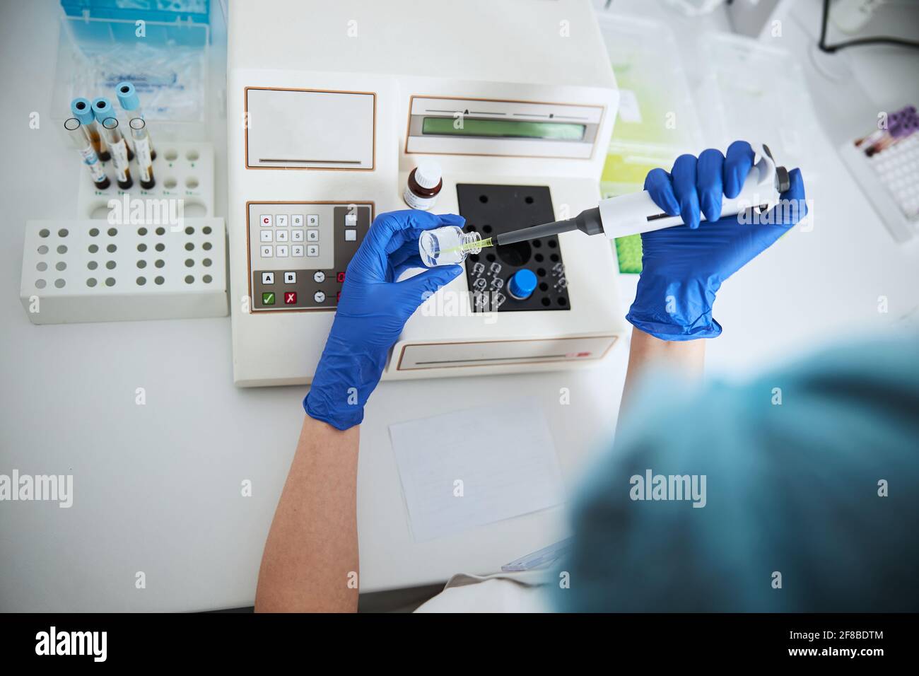 Biochemist drawing fluid into the plastic tip of the pipette Stock ...
