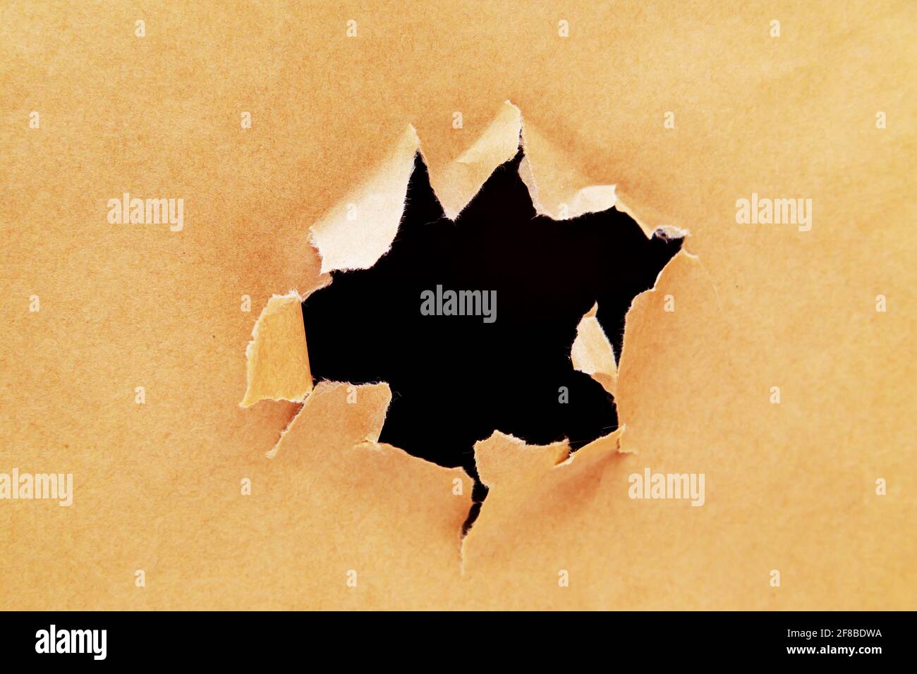 Kraft paper with a hole. Torn craft paper background Stock Photo - Alamy