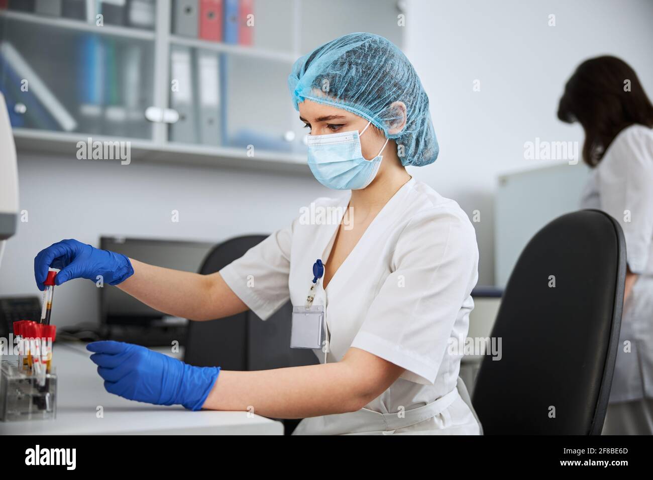 Biochemist choosing the red-top vacutainer for a hematological test ...