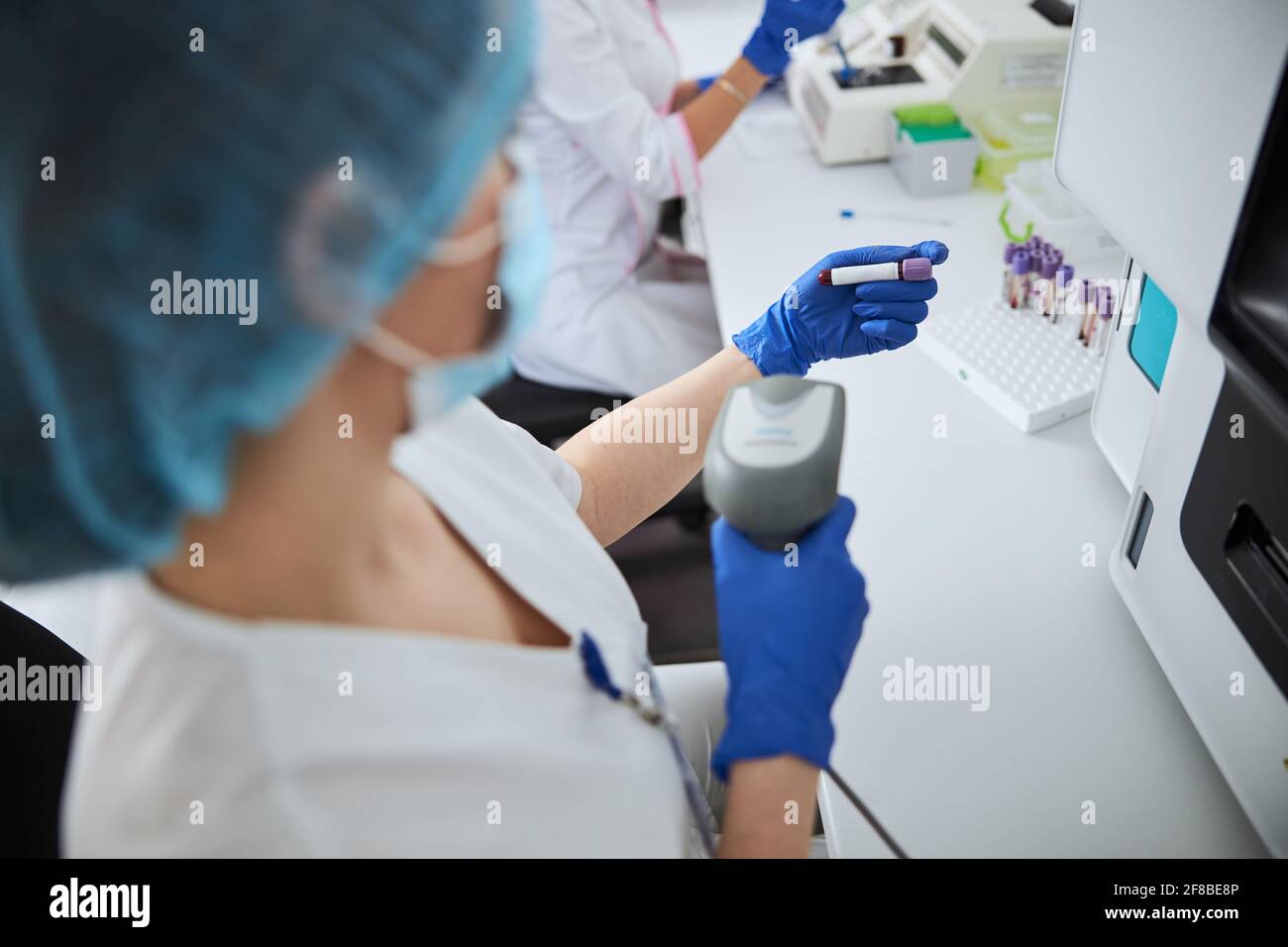 Female biochemist scanning the blood sample vacutainer Stock Photo - Alamy