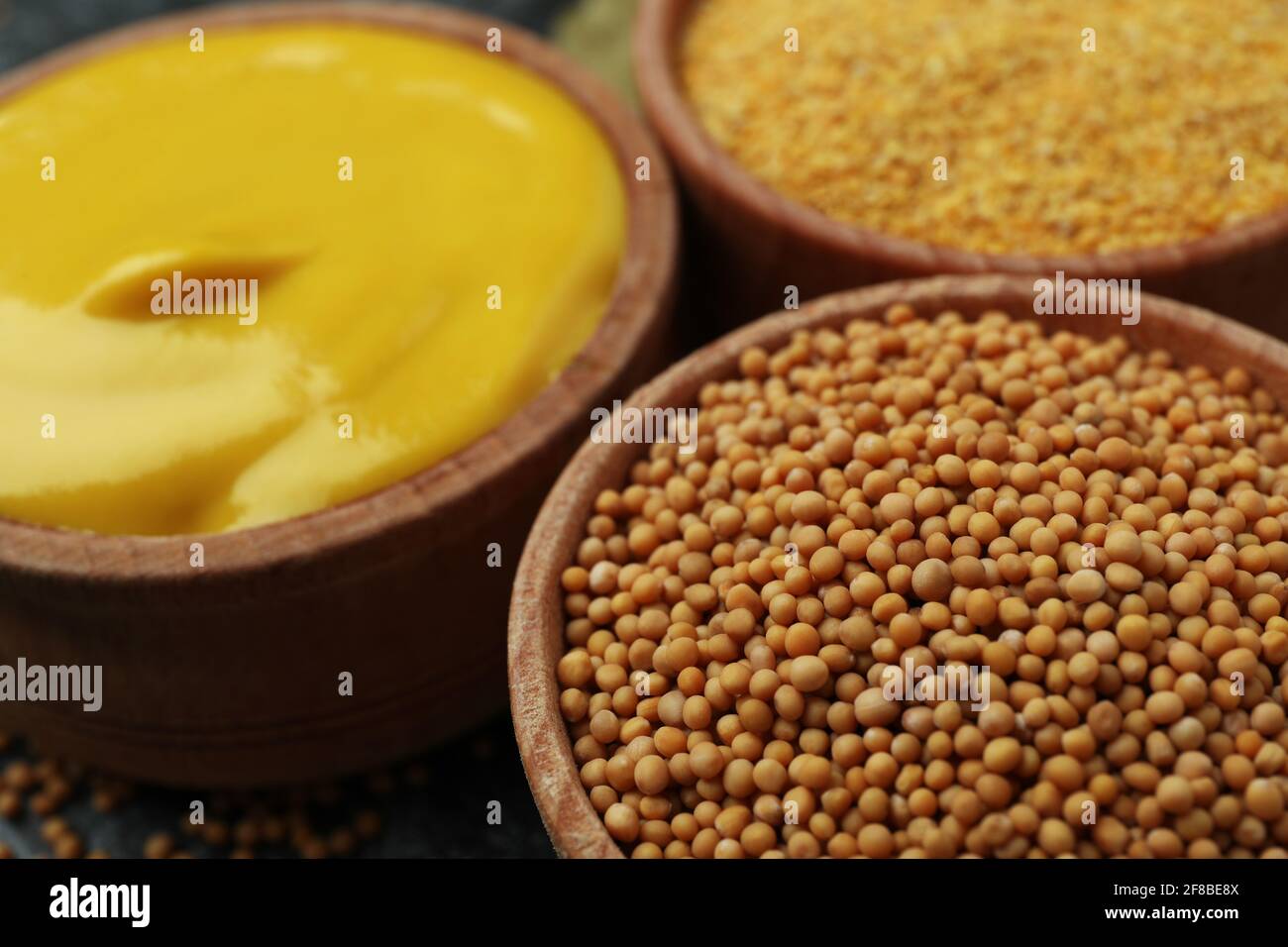 Wooden bowls with mustard seeds, sauce and powder, close up Stock Photo ...