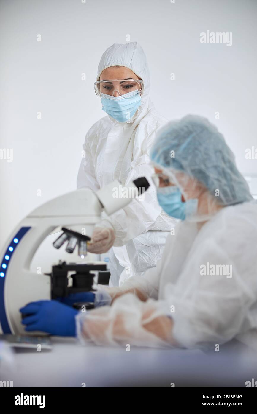 Scientists in hazmat suits examining a viral specimen Stock Photo - Alamy