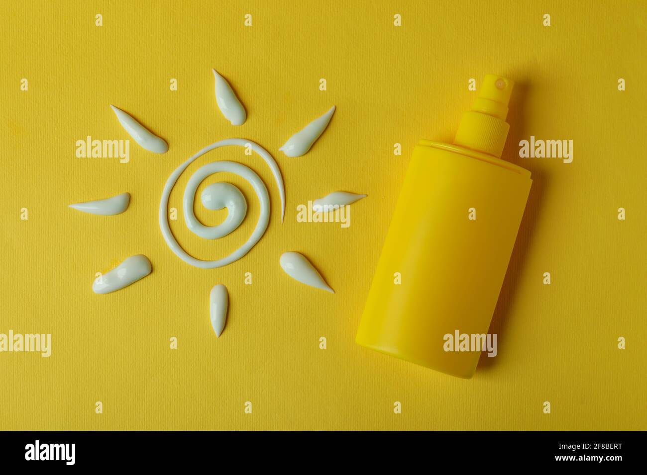 Sun made of sunscreen and bottle of cream on yellow background Stock ...