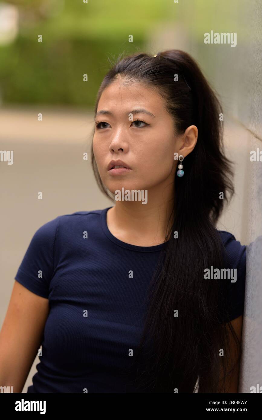 Portrait of beautiful rebel Asian woman thinking outdoors Stock Photo ...