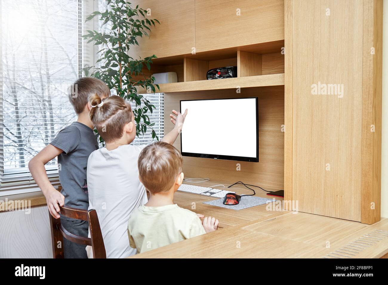 Schoolboy shows white screen of computer to interested friends sitting ...