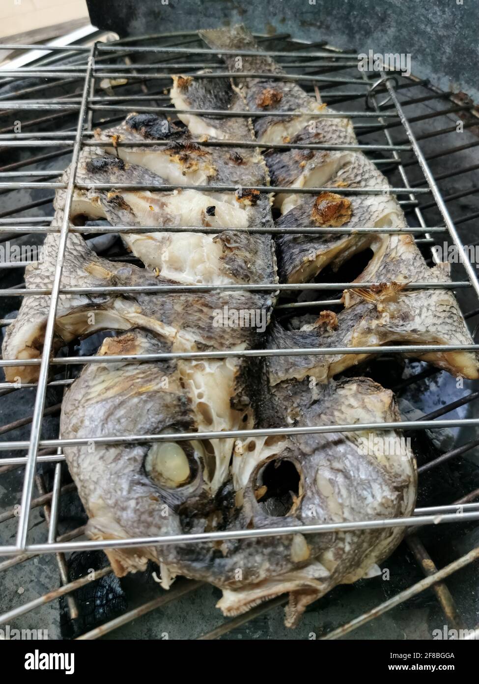 Detailed view of fish grilled over a burning coal fire, healthy and ...
