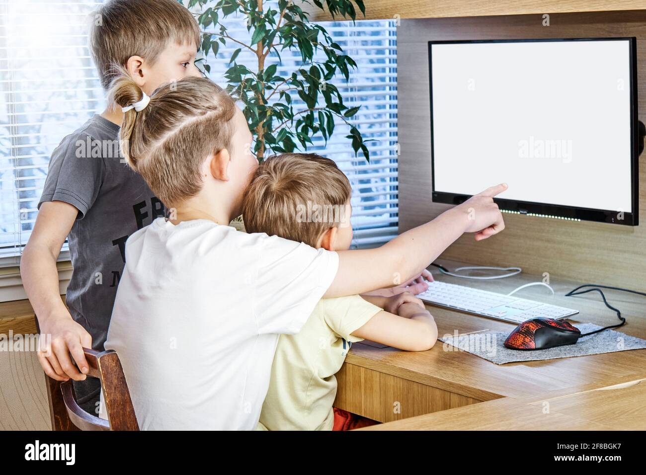 Schoolboy shows white screen of computer to interested friends sitting ...