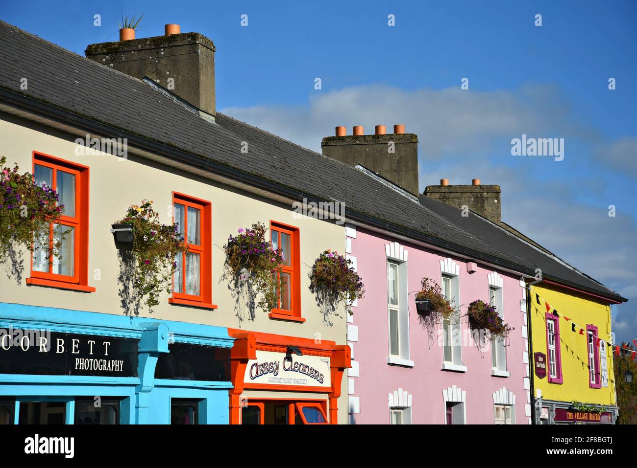 Colorful facades of English style buildings on the Main street of Adare ...