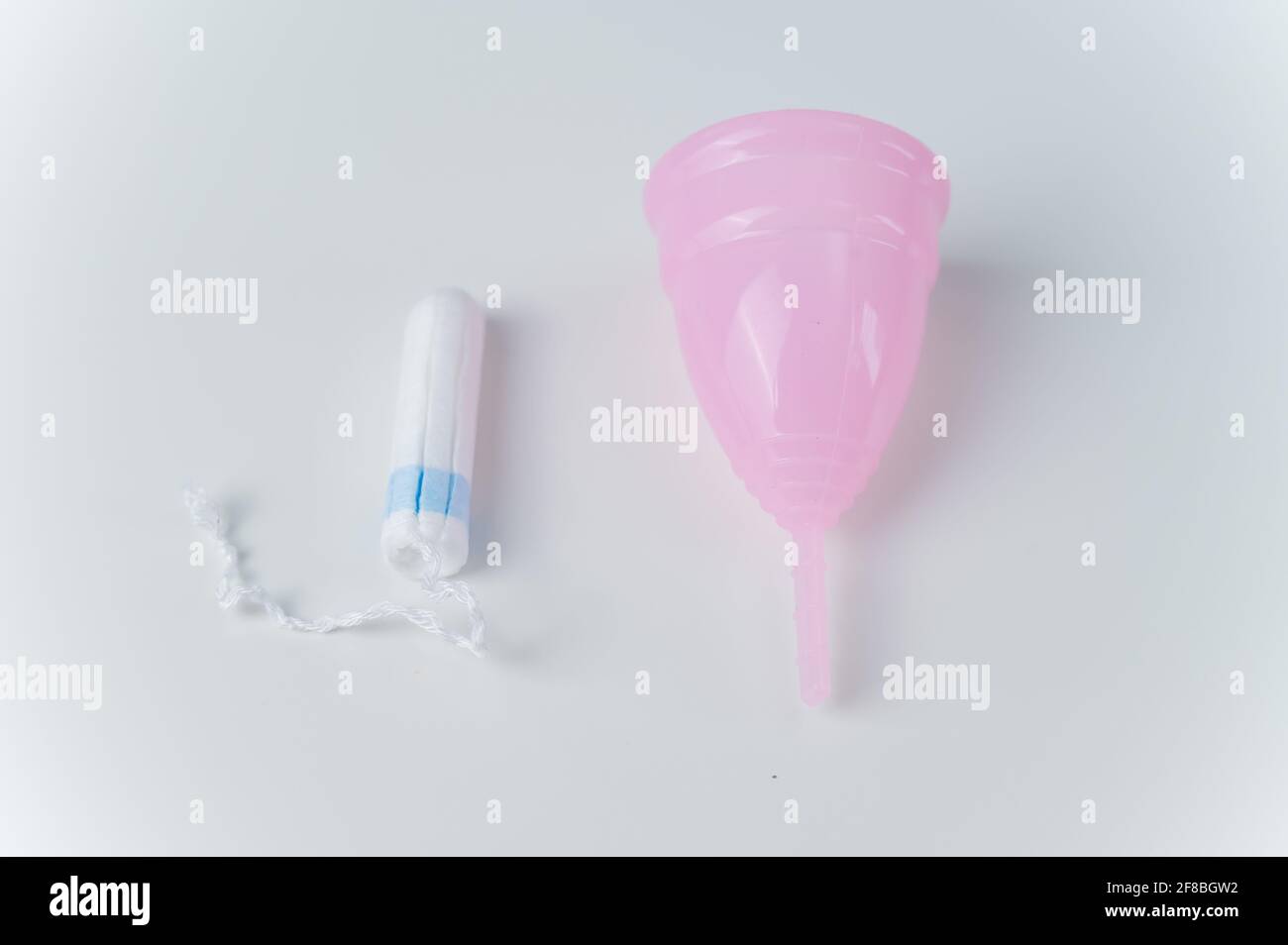 Pink menstrual cup and tampon on a white background. Various hygiene ...