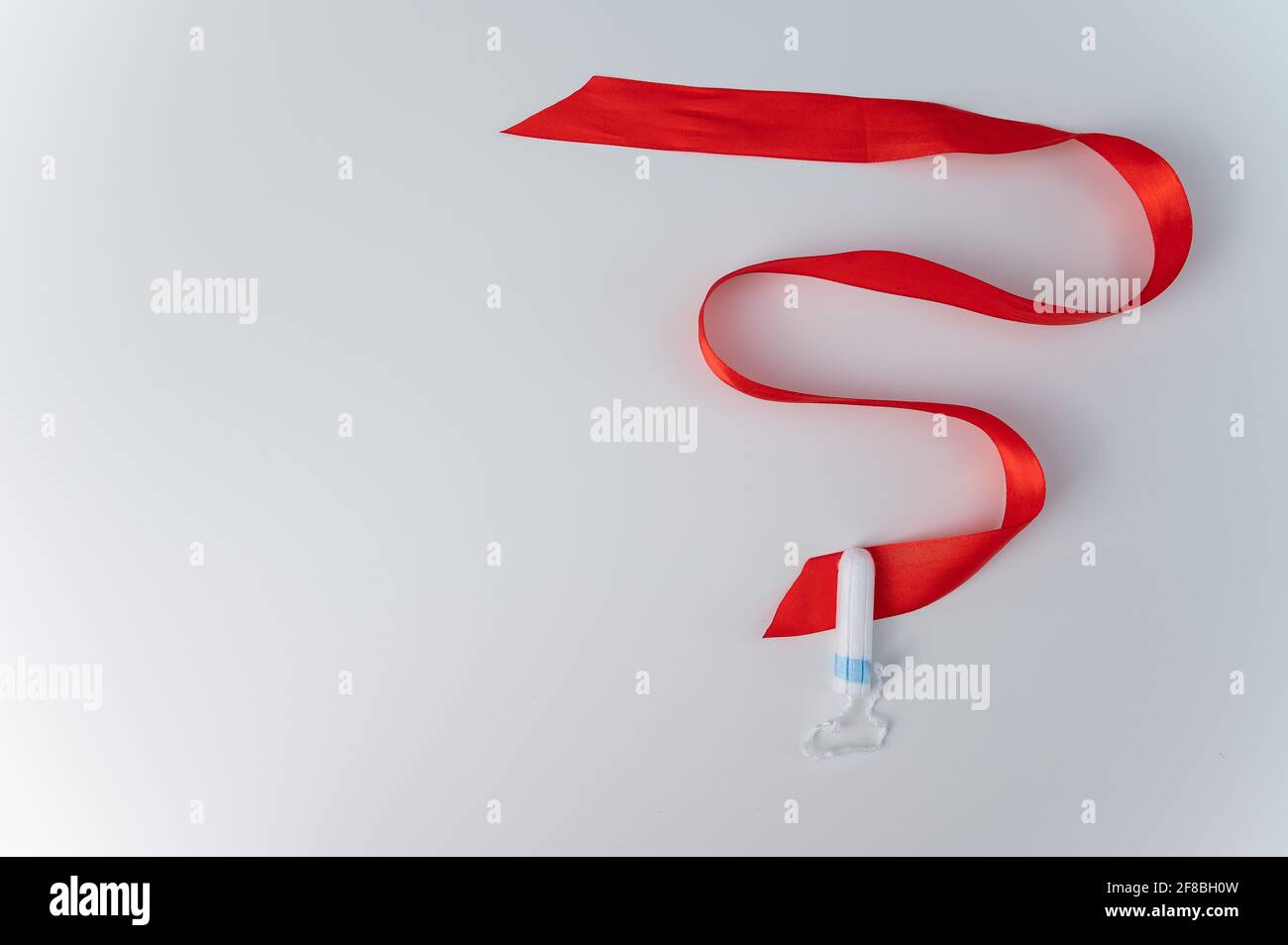 Tampon and red satin ribbon on a white background. Means of intimate ...
