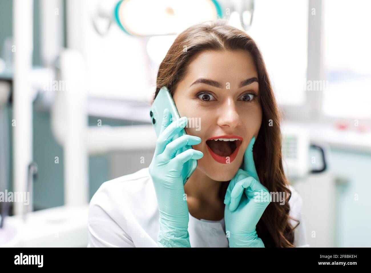 Serious female doctor talking on mobile phone at his desk Stock Photo ...