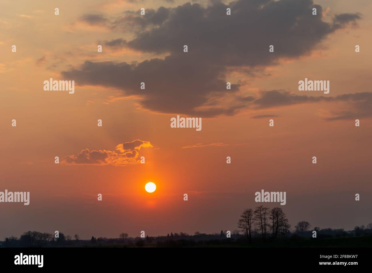 Round sun and hazy pink sky with clouds, sunset view Stock Photo - Alamy
