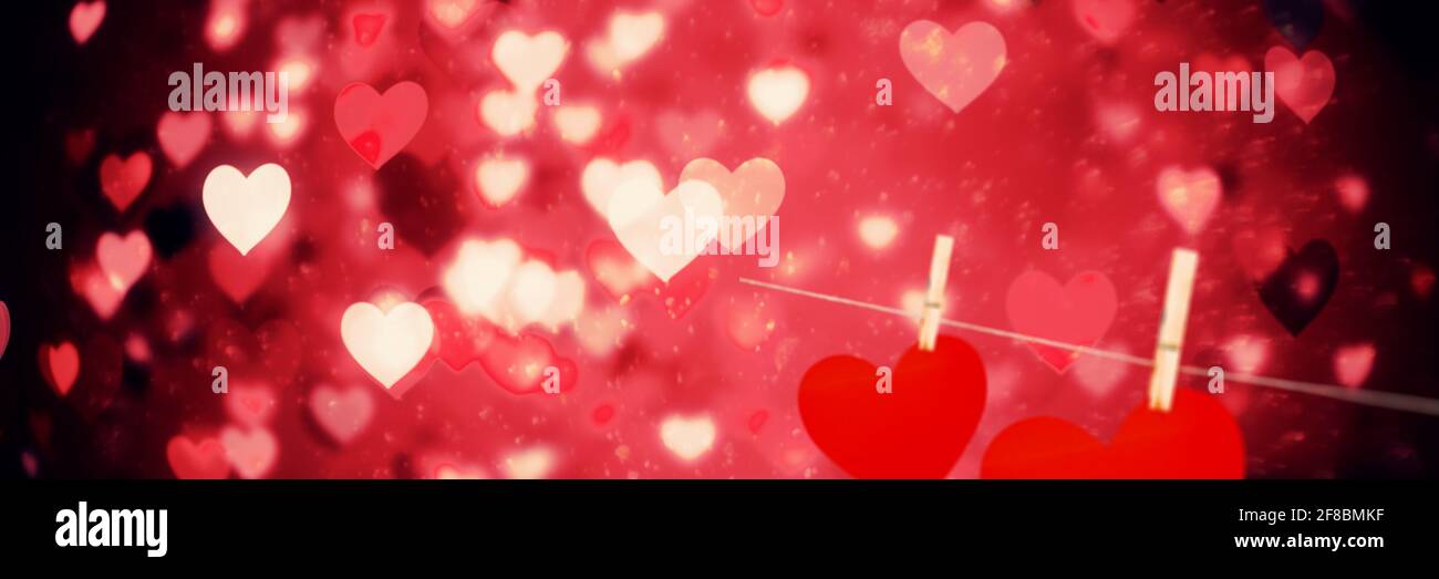 Red heart shapes on a string against red background Stock Photo - Alamy