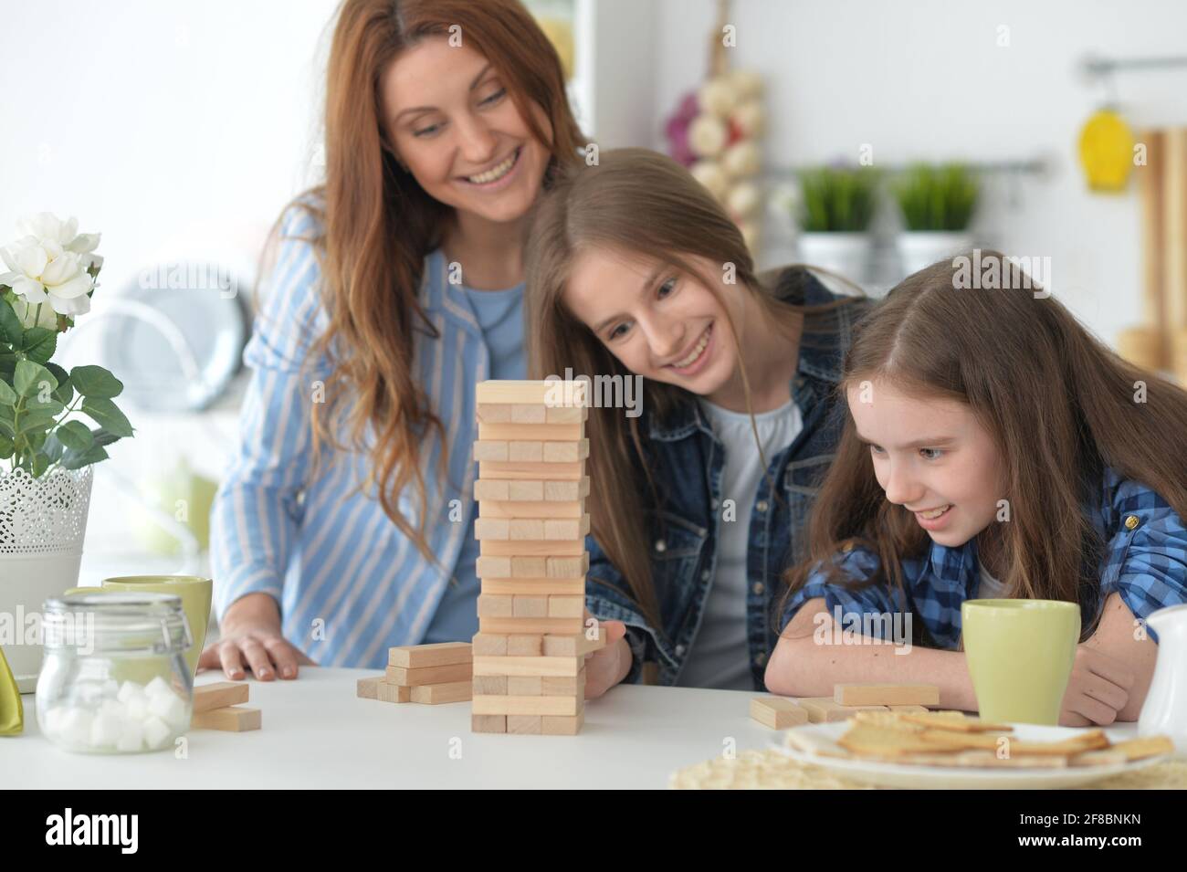 Young mother and her daughters playing with a wooden blocks Stock Photo - Alamy