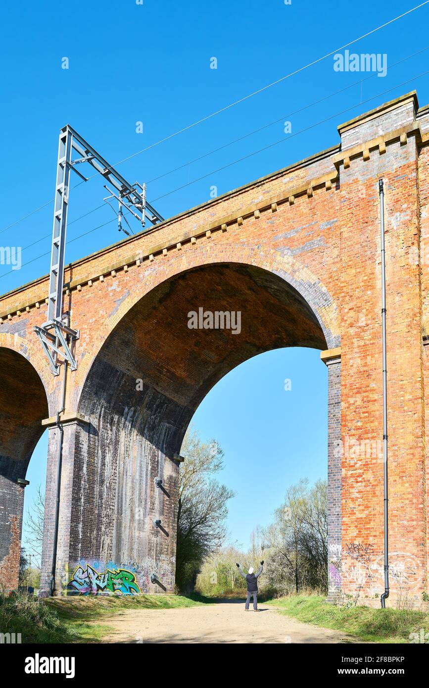 A senior man points up at the newly electrified railway line on the ...