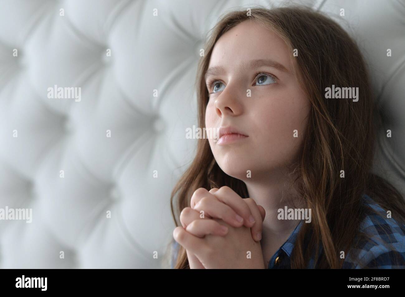Cute girl praying isolated on white background Stock Photo - Alamy