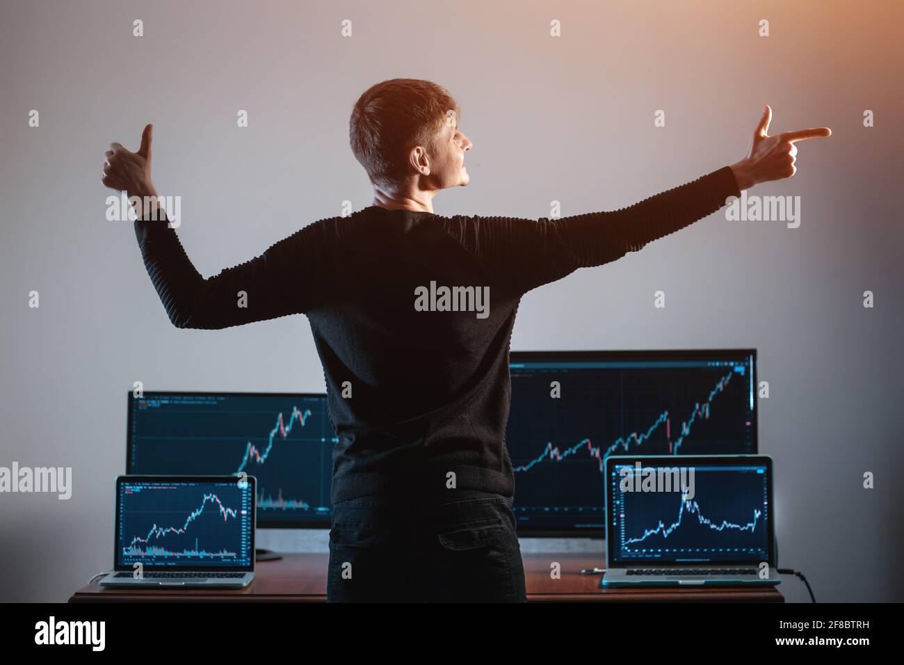 successful male trader looking at monitor with stock exchange graph or ...