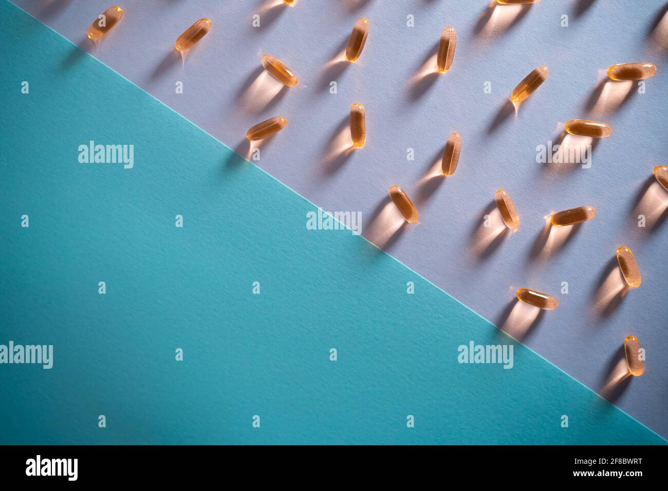 healthy golden fish oil capsules omega 3 vitamins on purple and blue ...