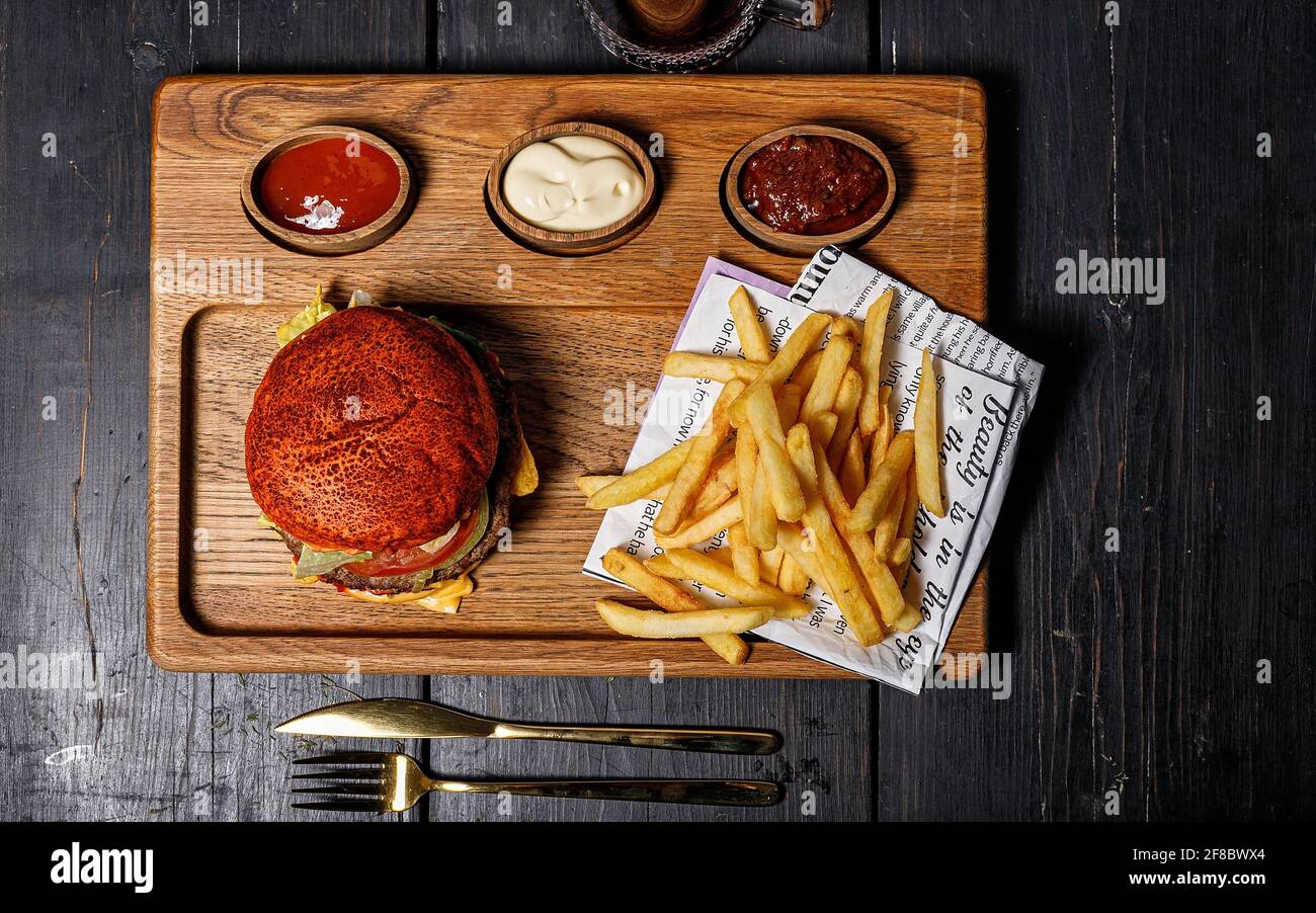 Delicious double beef burger and a serving of French fries on a wooden ...