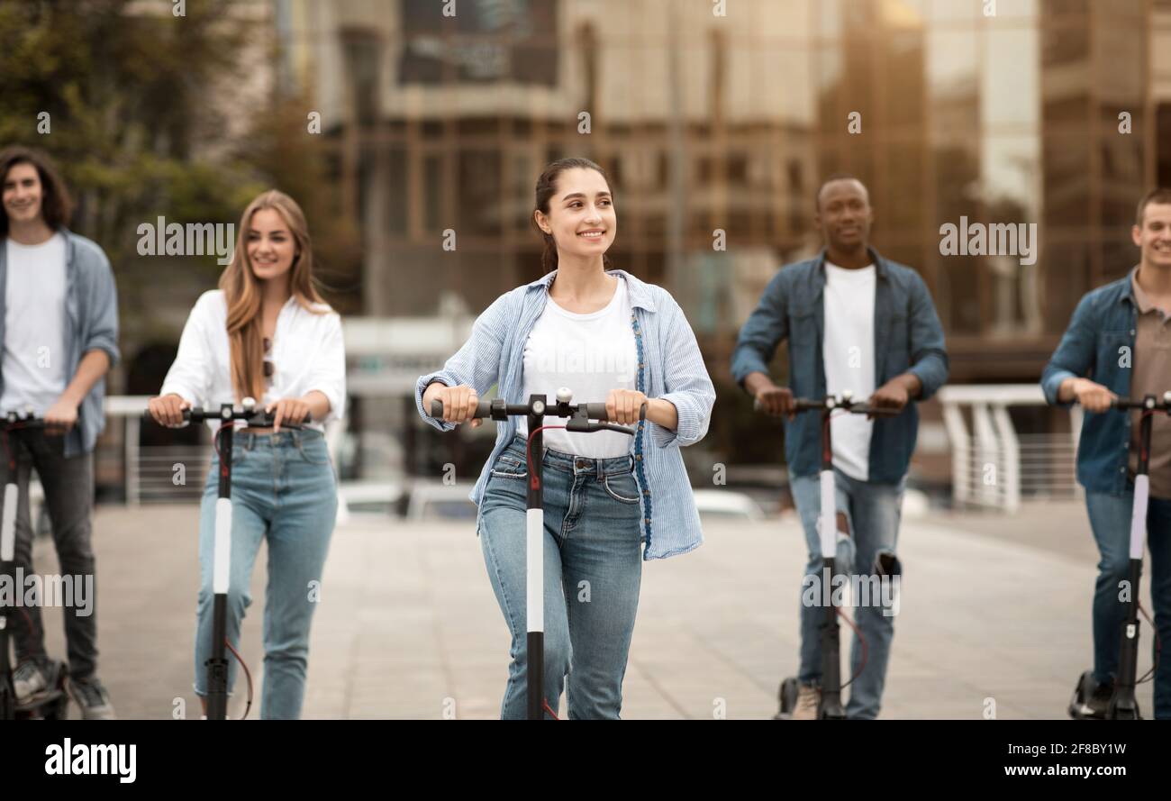 Five friends having pleasant ride on motorized kick scooters Stock ...