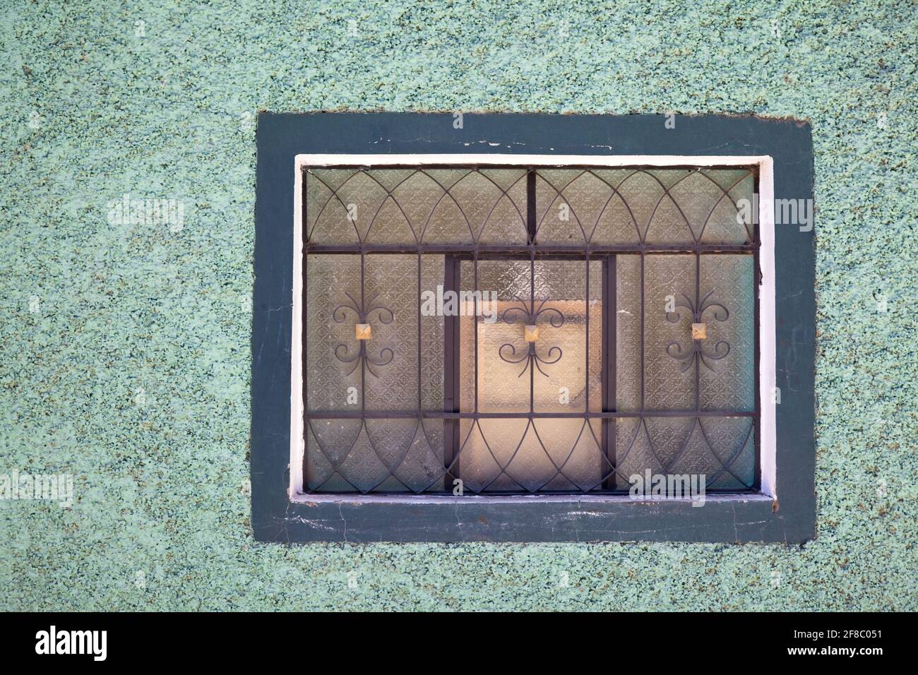 Street shot of barred window of colorful adobe traditional house in ...